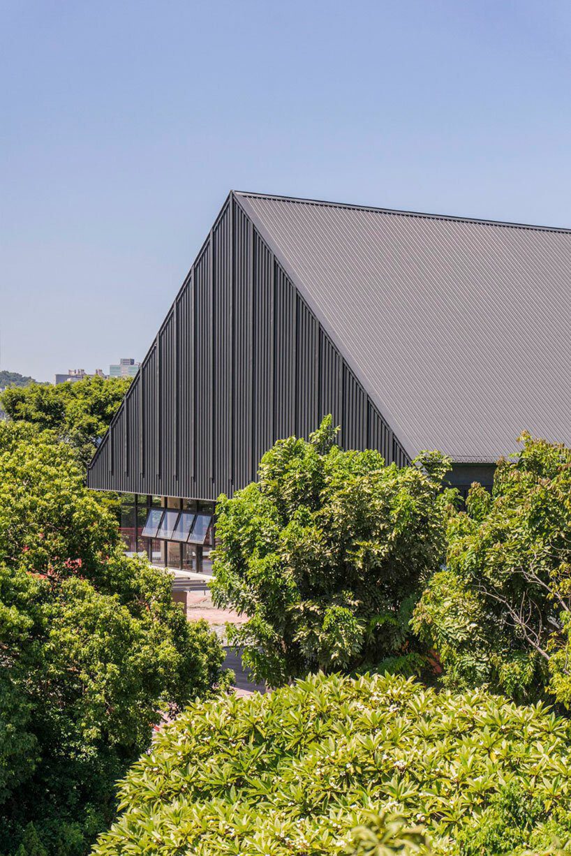 triangular metal roof crowns elevated sports hall in taiwan school ...